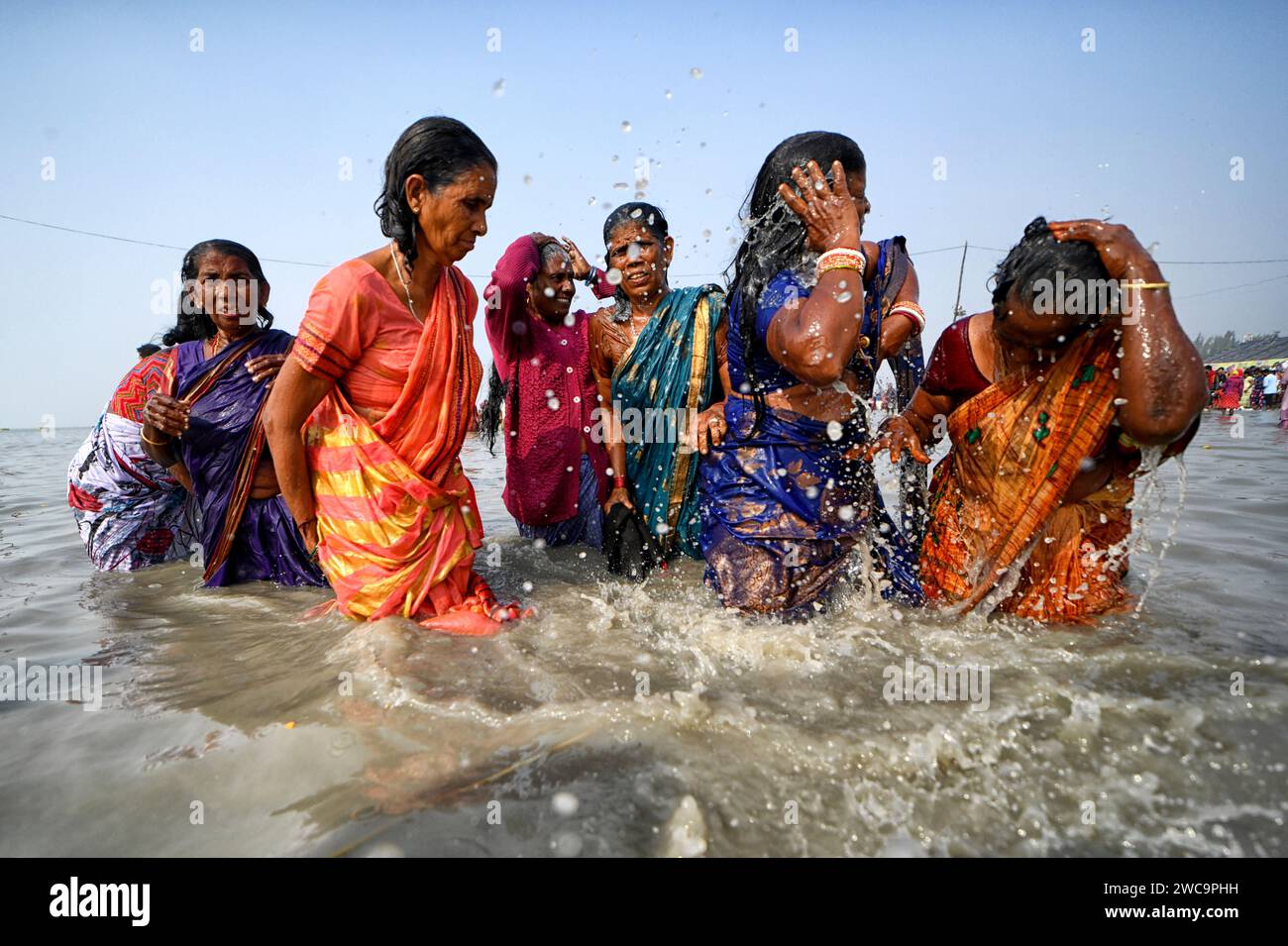 Sagar Island, India. 14th Jan, 2024. Hindu women pilgrims take a Holy ...