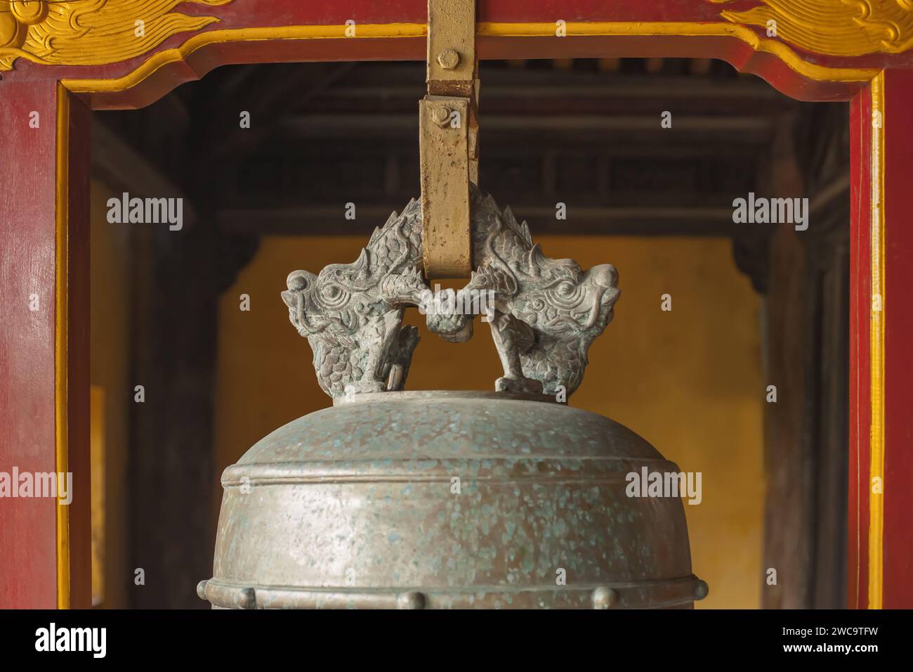 A detailed view of a bronze bell adorned with traditional dragon motifs ...
