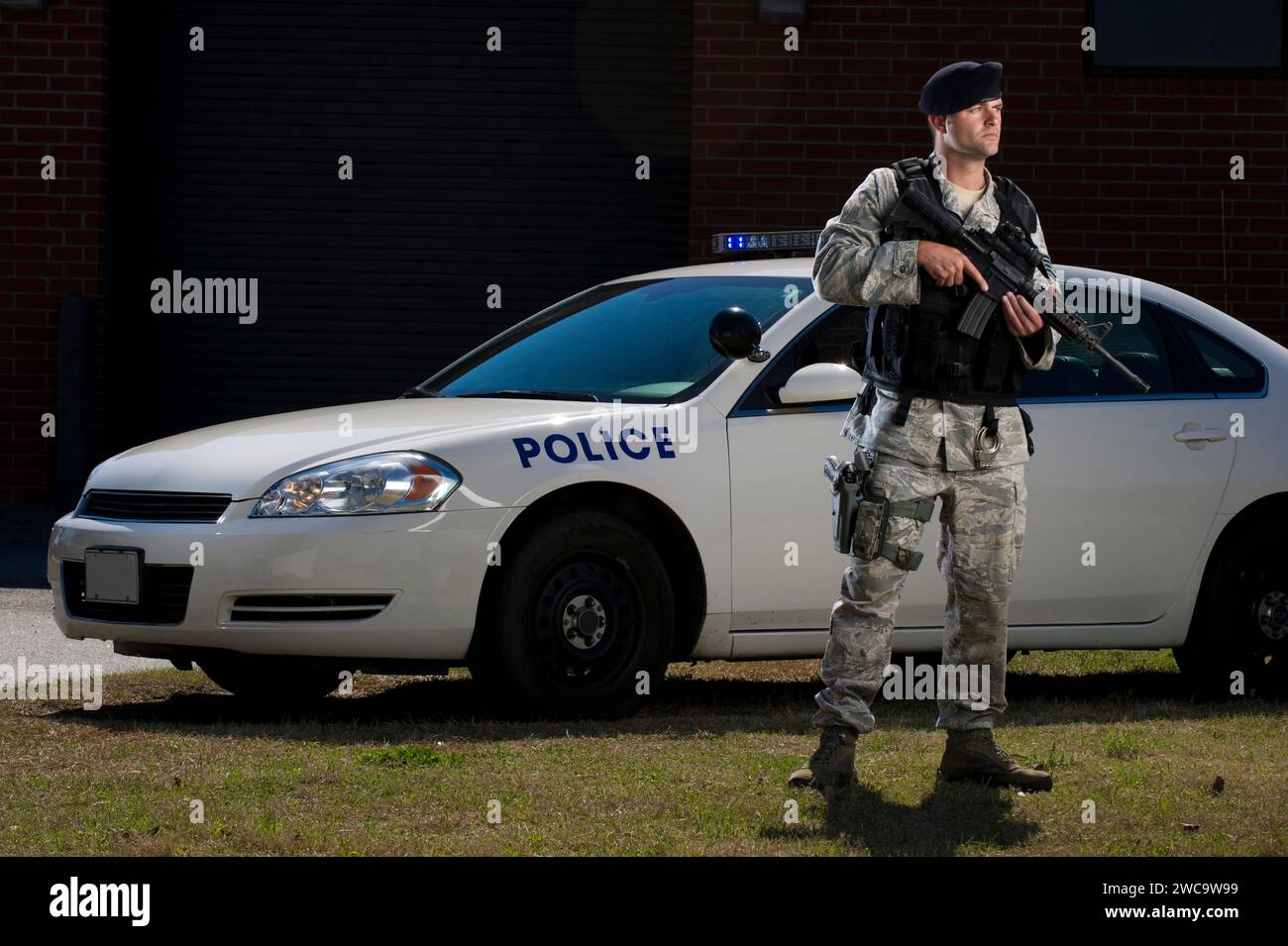 A military police officer makes a call over the radio near his police ...