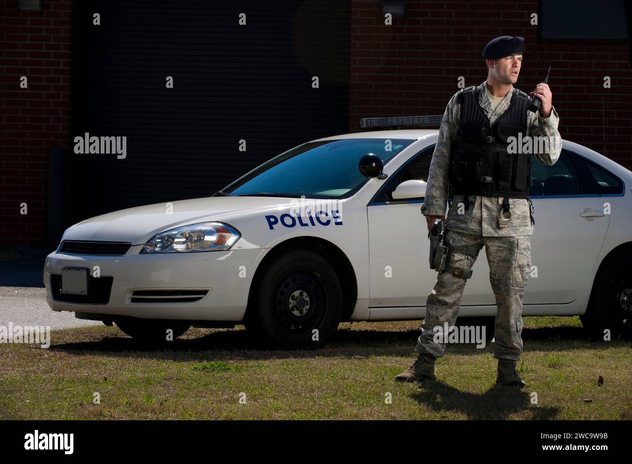 A military police officer makes a call over the radio near his police ...
