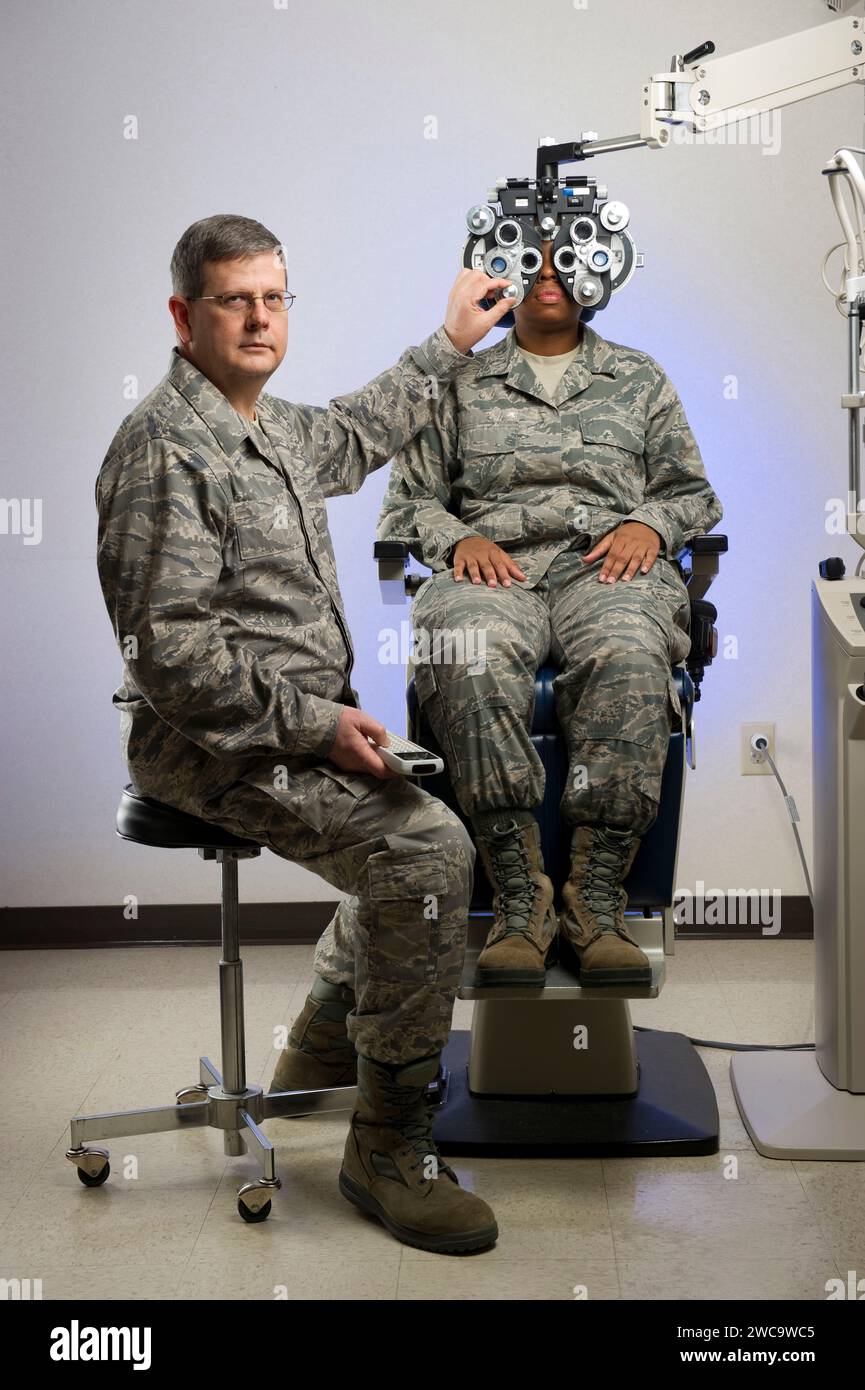 A military optometrist checks the eye site of another service member ...
