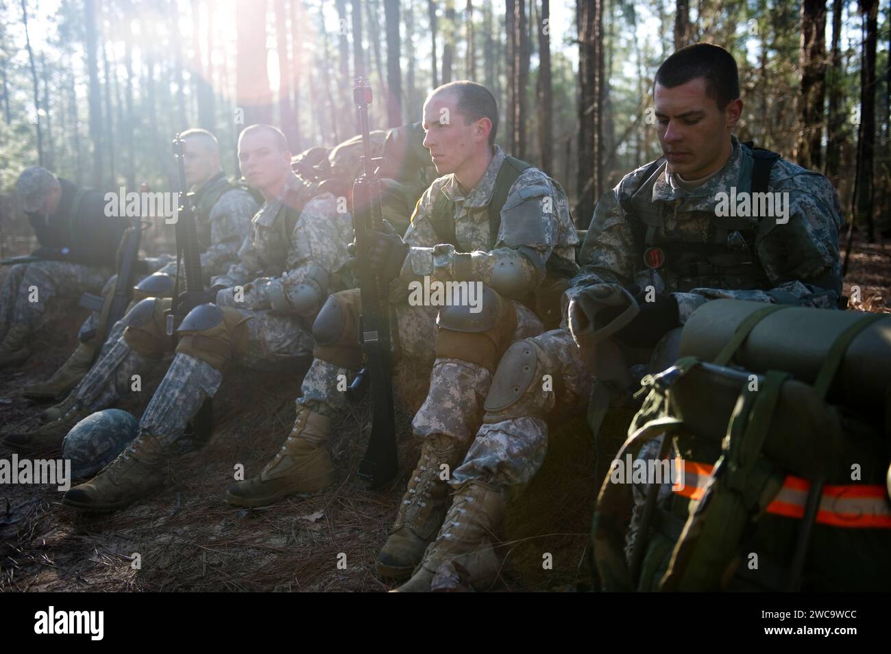 Soldiers listen to their instructors while sitting on the side of a ...