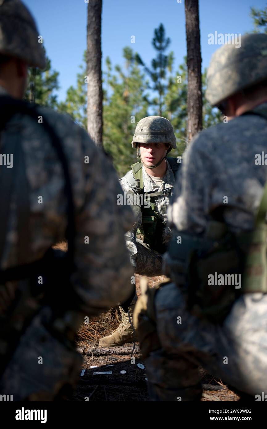 Soldiers listen to their team captain during a field training exercise ...