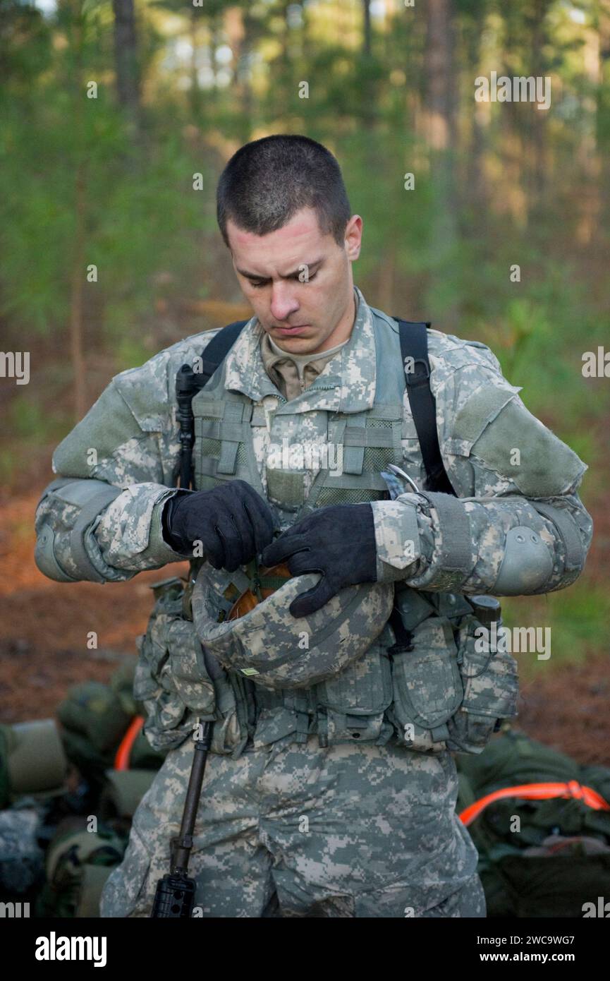 A soldier adjusts his helmet before heading out on a combat patrol ...