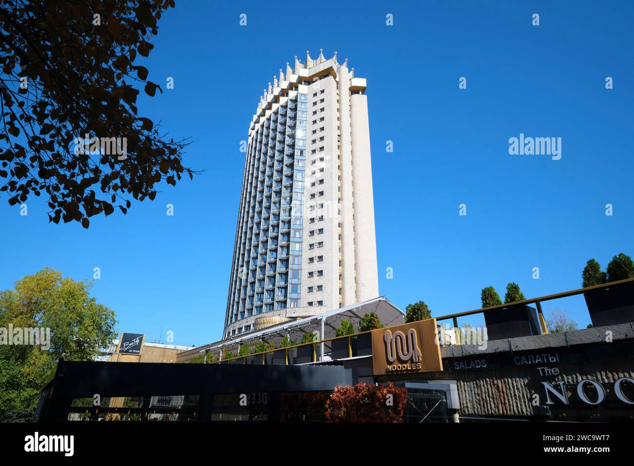 A view through the trees of the iconic, 26 floor Hotel Kazakhstan ...
