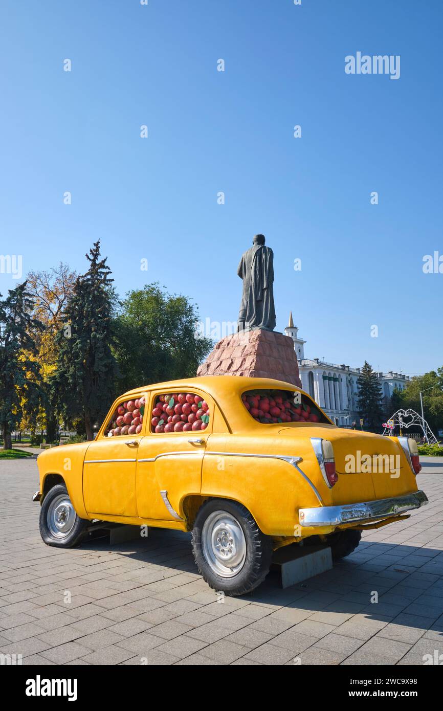 An old yellow Moskvich car, filled with fake red apples. It is an art ...