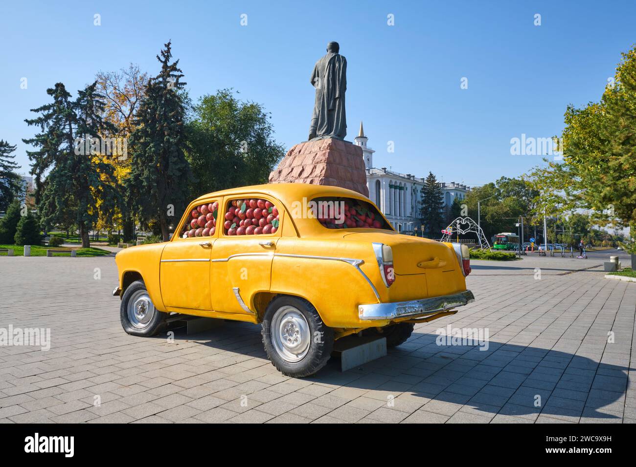 An old yellow Moskvich car, filled with fake red apples. It is an art ...