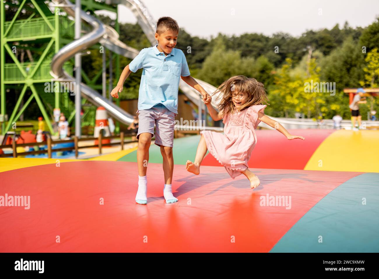 Kids jumping on inflatable trampoline in amusement park Stock Photo - Alamy