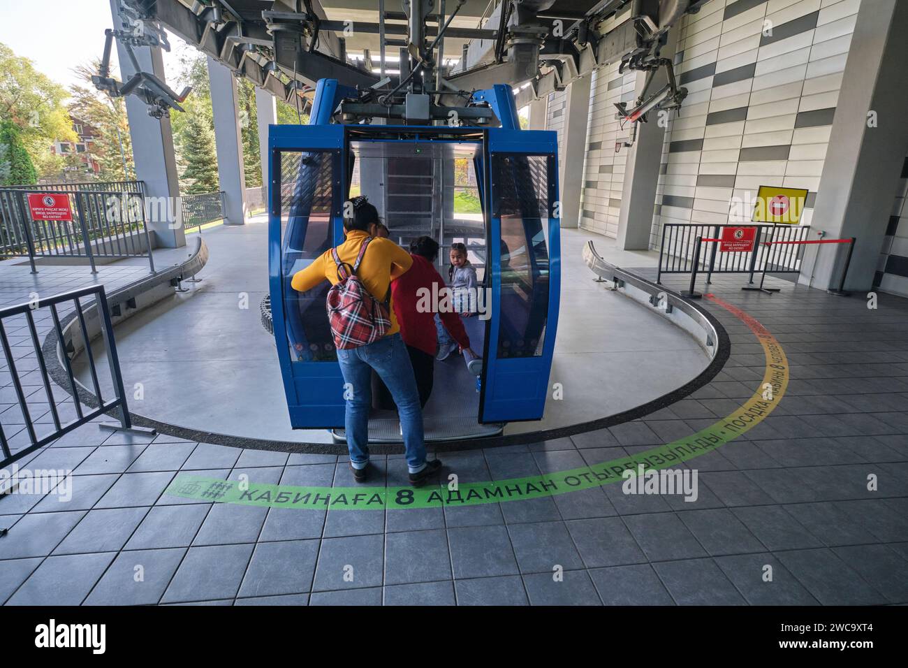 A tourist family gets on one of the cable cars going up the mountain to ...