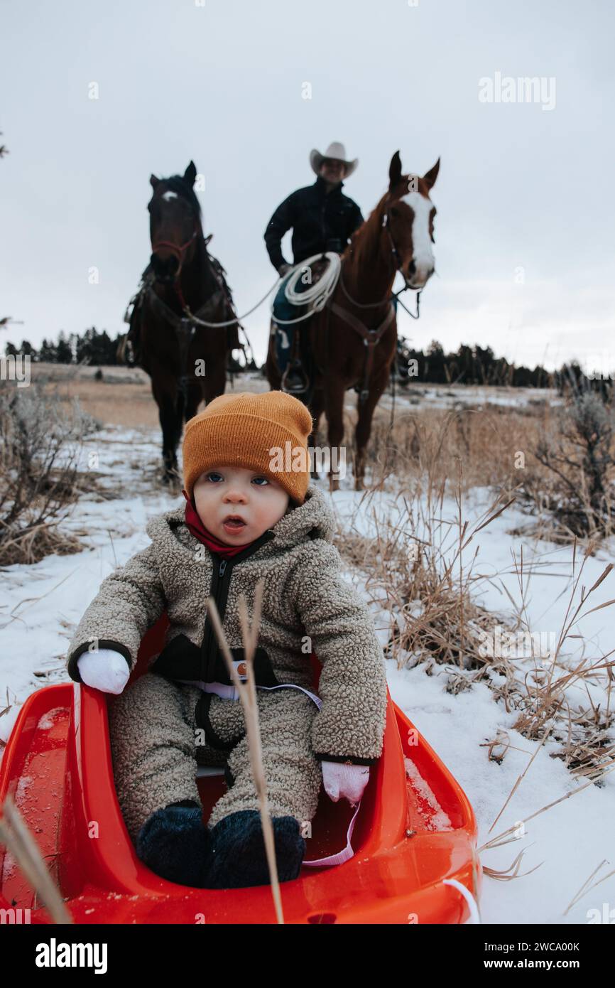Proud cowboy smiles behind son on horse Stock Photo - Alamy