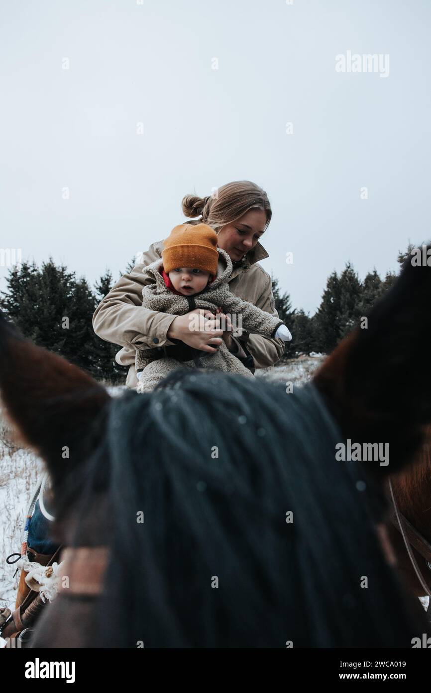 Mom holds baby, joyfully riding horse together Stock Photo - Alamy
