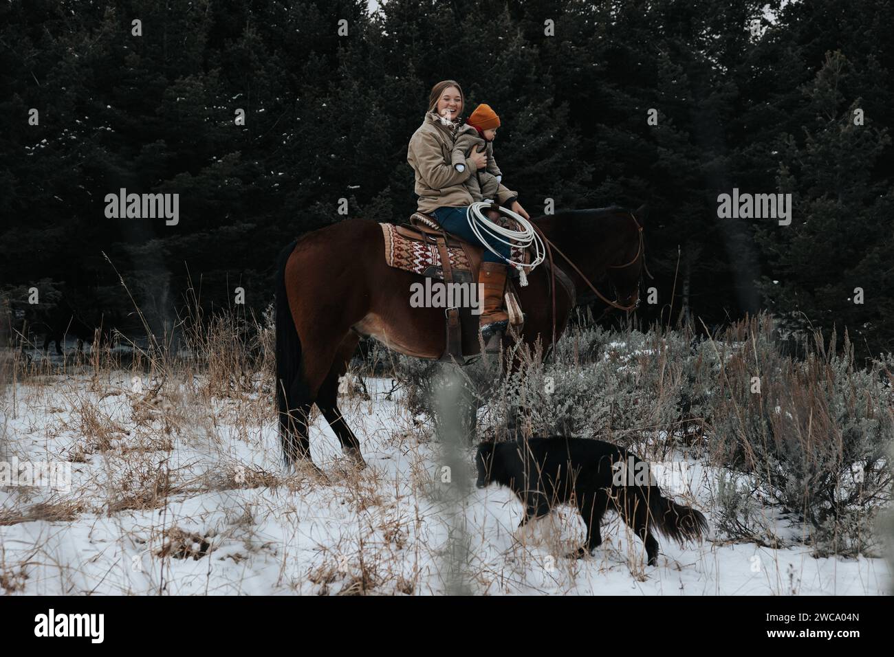 Mom holds baby, joyfully riding horse together Stock Photo - Alamy