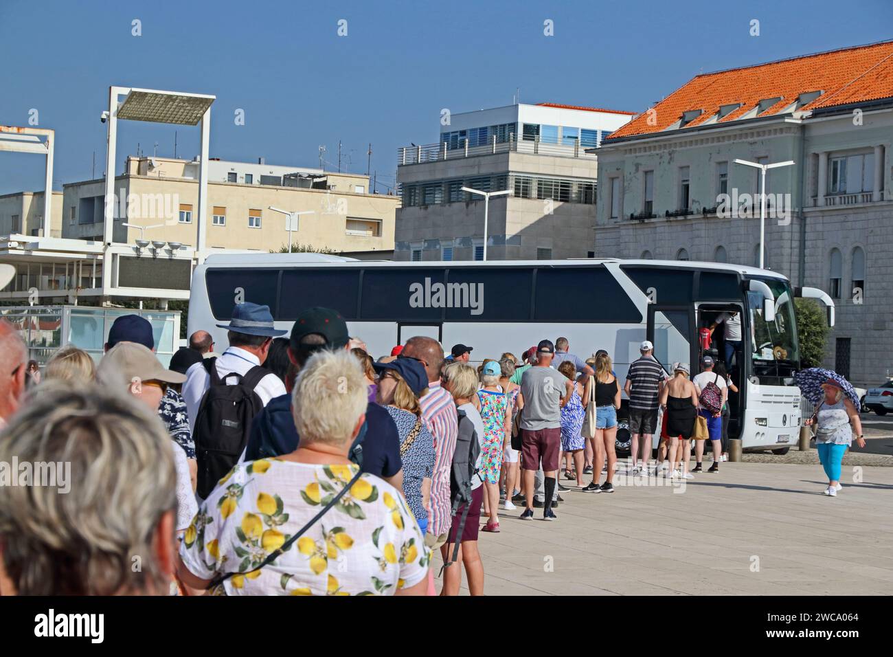 Queue of passengers waiting to board coaches back to cruise ship, Zadar ...