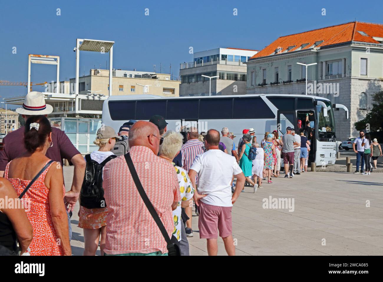 Queue of passengers waiting to board coaches back to cruise ship, Zadar ...