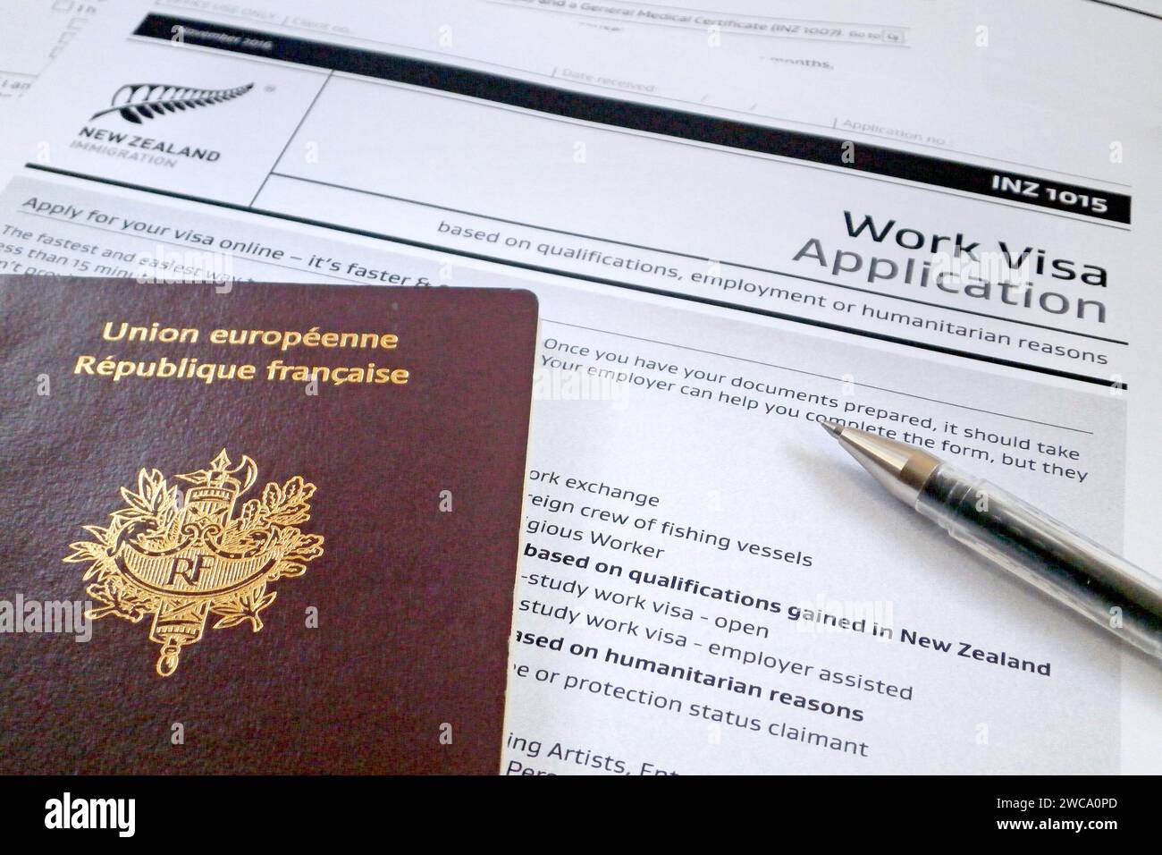 A French passport and a pen on the top of a work visa application form ...