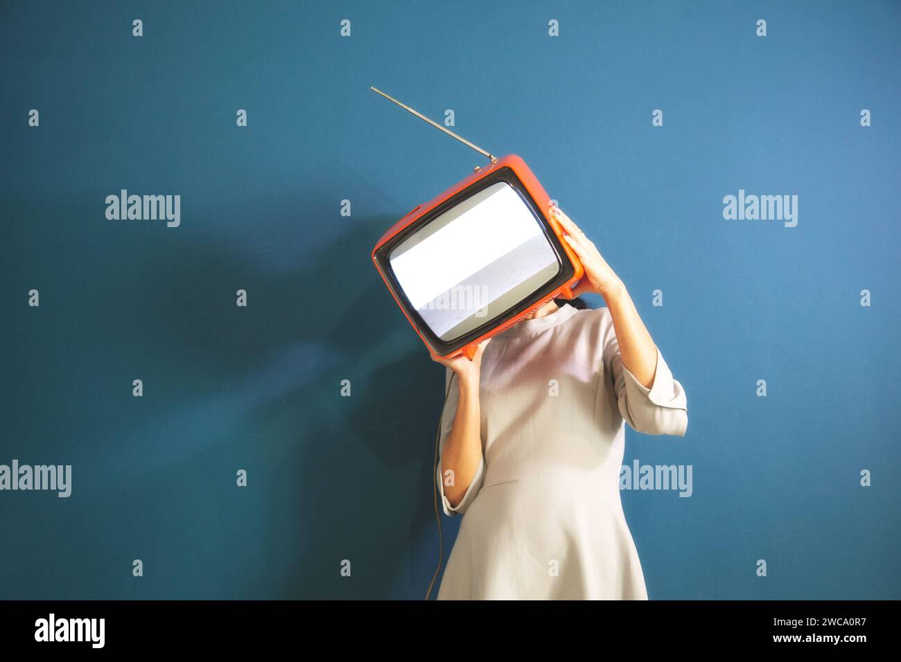 surreal woman covers her face with a television without connection ...