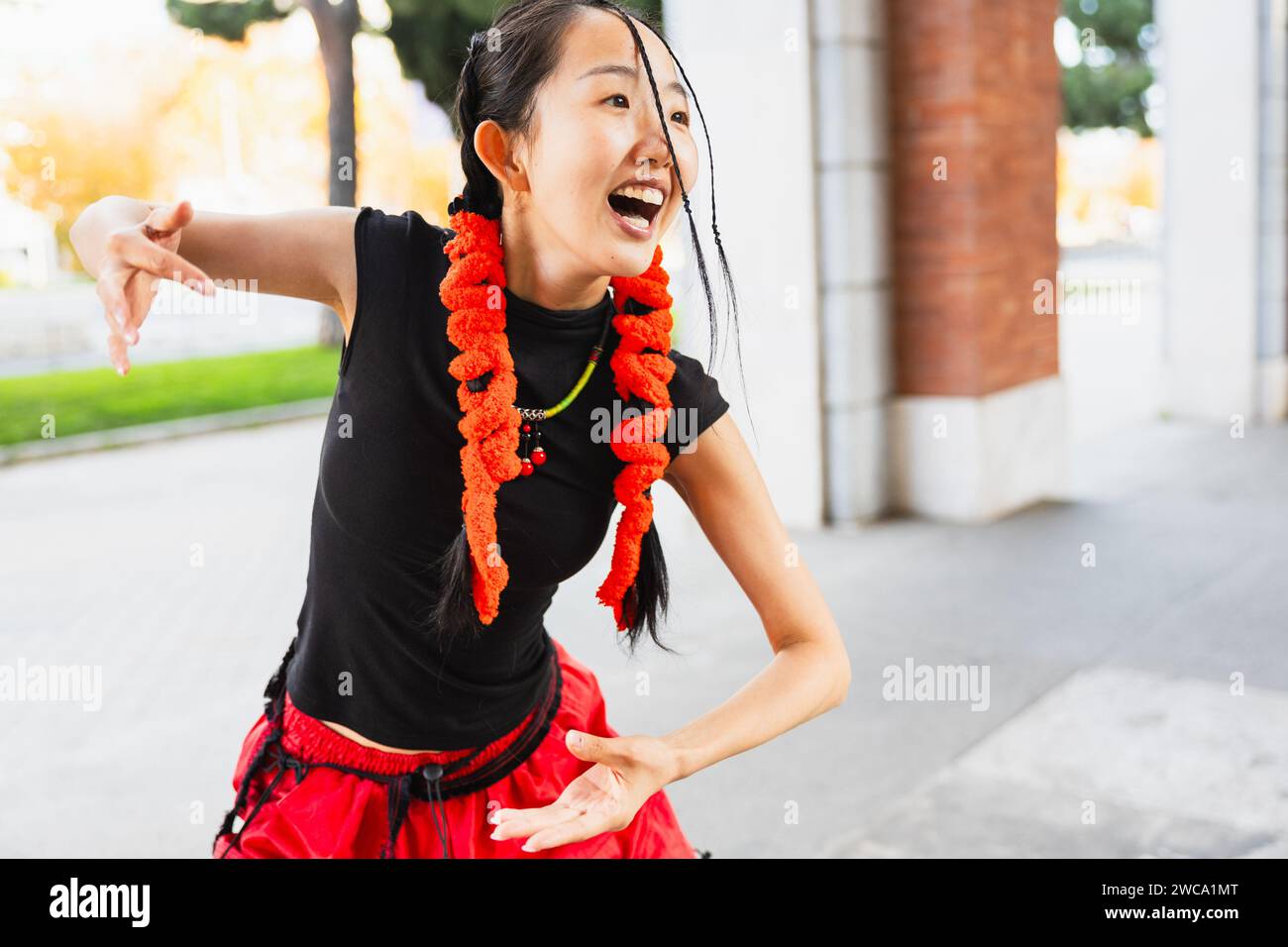 Portrait of Asian woman with an original hairstyle smiling while ...