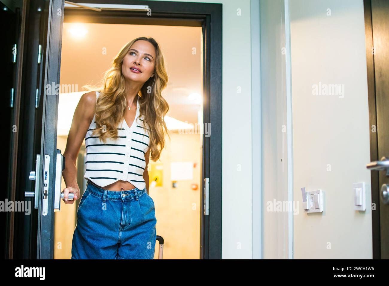 Woman opening door hotel room hi-res stock photography and images - Alamy