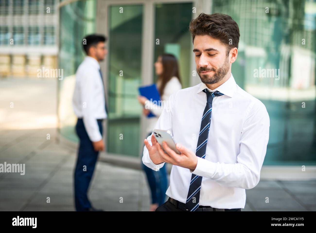 Smiling businessman in front of a group of colleagues, teamwork concept ...