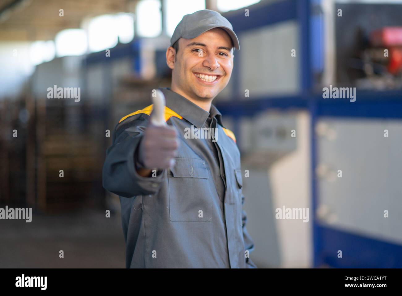 Smiling mechanical worker giving thumbs up Stock Photo - Alamy