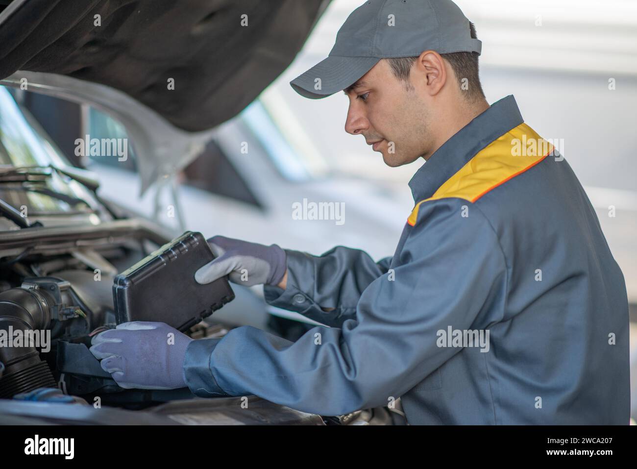 Car mechanic putting oil in a van engine Stock Photo - Alamy