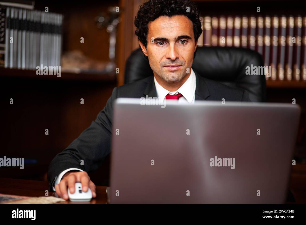Professional male executive working on a laptop in a well-appointed ...