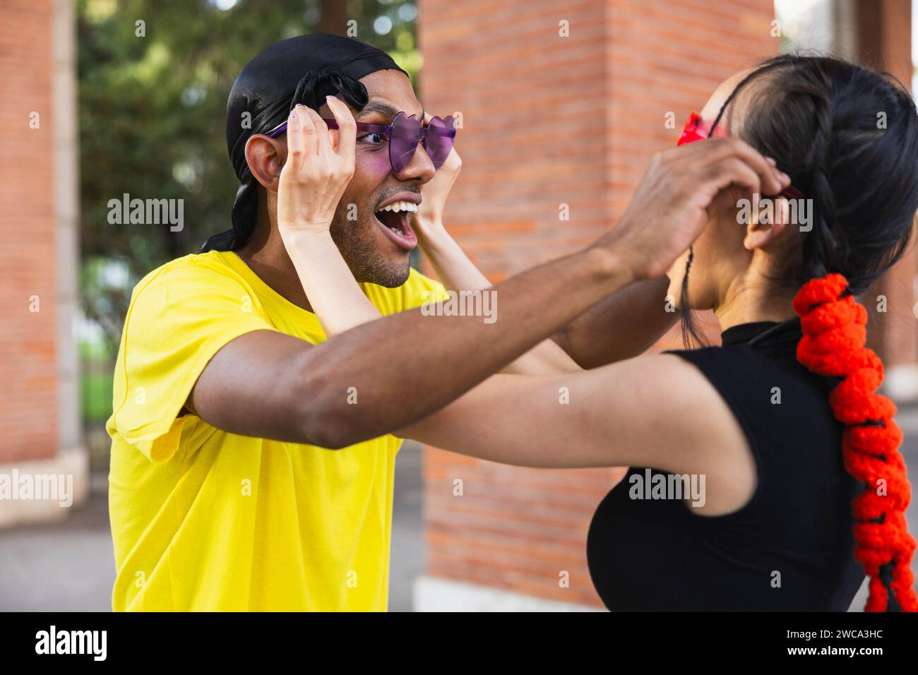 "Close-up of a joyful, smiling woman in purple sunglasses embracing her ...