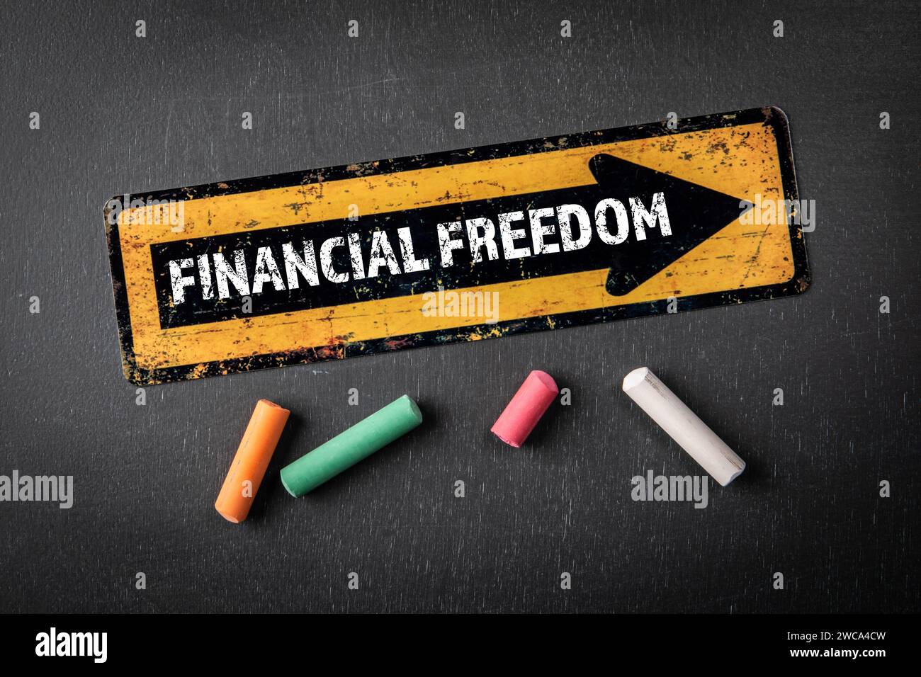 Financial Freedom. Direction arrow with text on a dark chalkboard ...