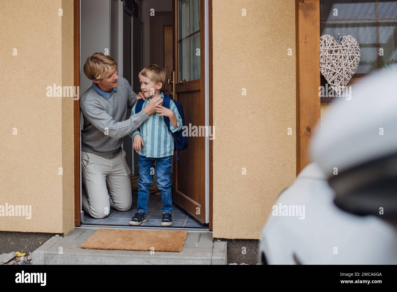Boy getting ready for school, putting on shoes, getting dressed. Father ...