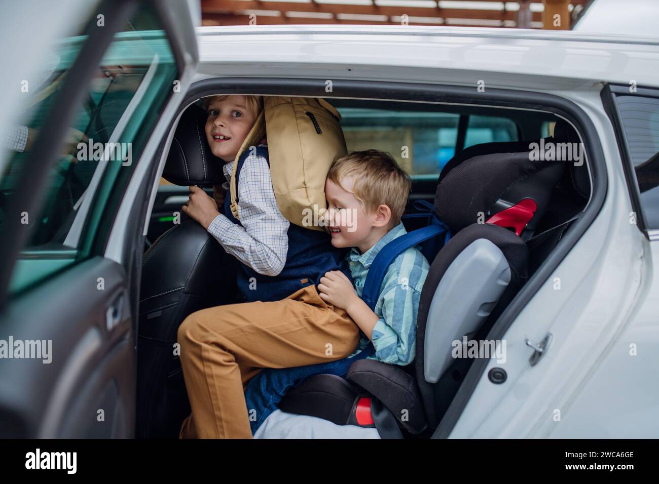 Children getting into the car, father taking them to school and ...