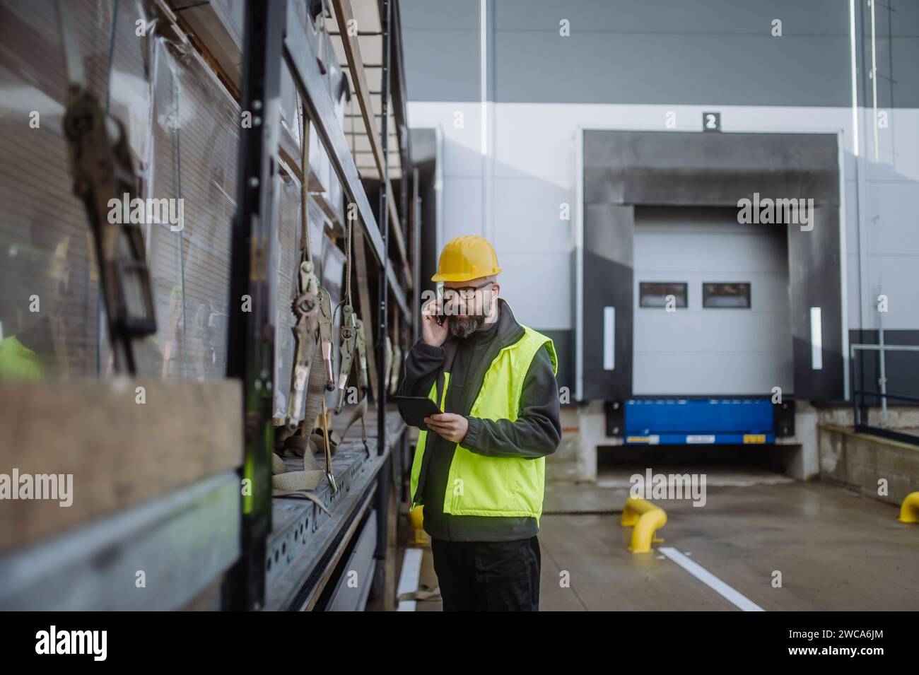 Warehouse receivers unloading of the truck in front of warehouse, phone ...