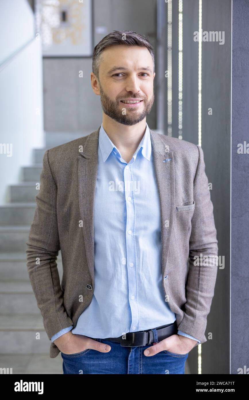Confident professional man in smart casual attire smiling in modern ...