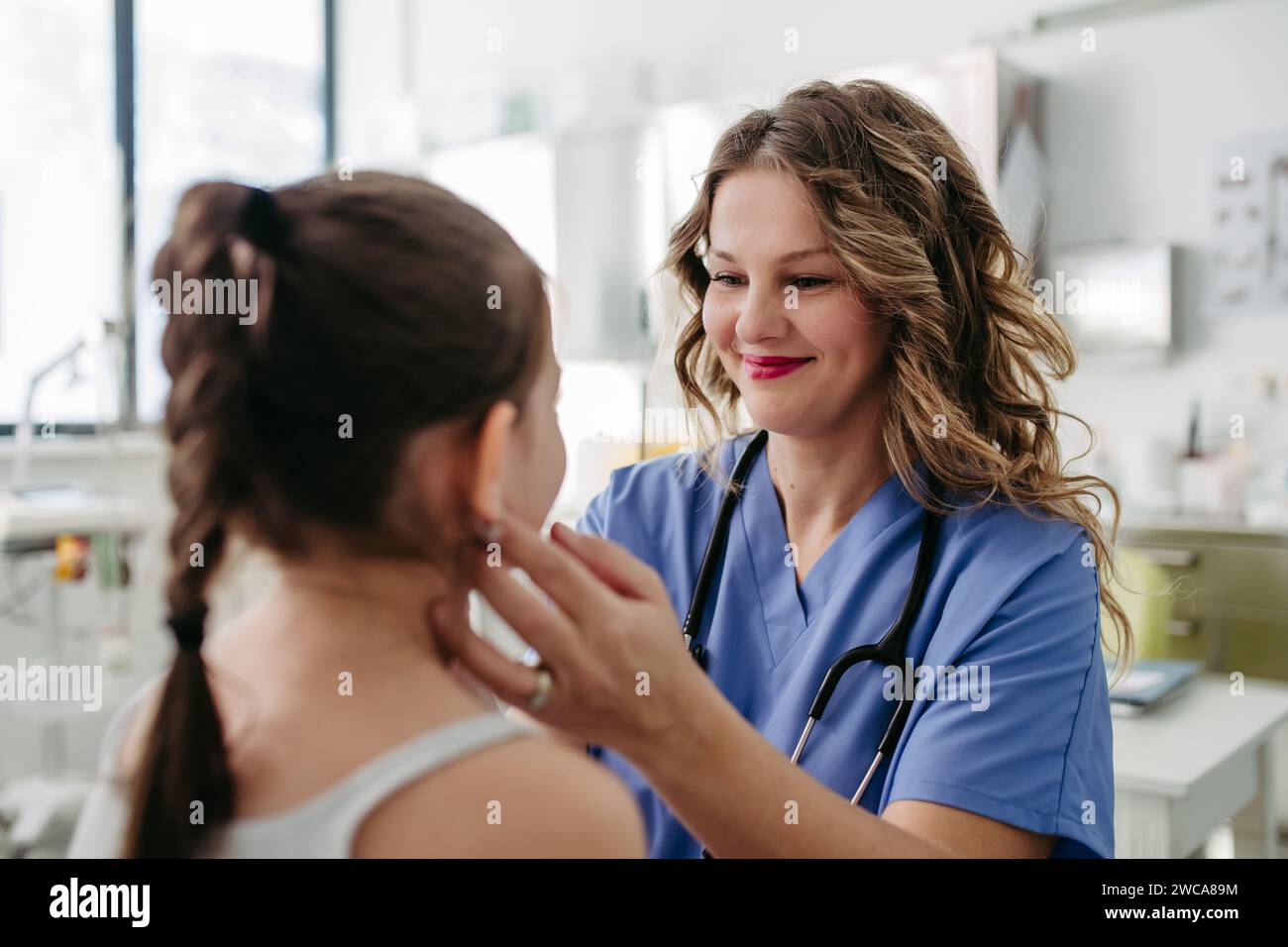 Doctor examining lymp nodes on neck of the young girl. Palpation of ...