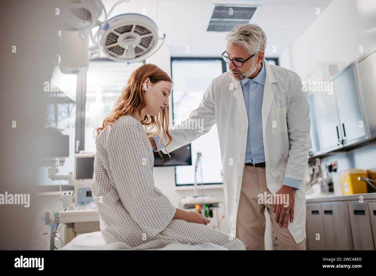 Doctor delivering bad news to teenage patient in hospital, discussing ...