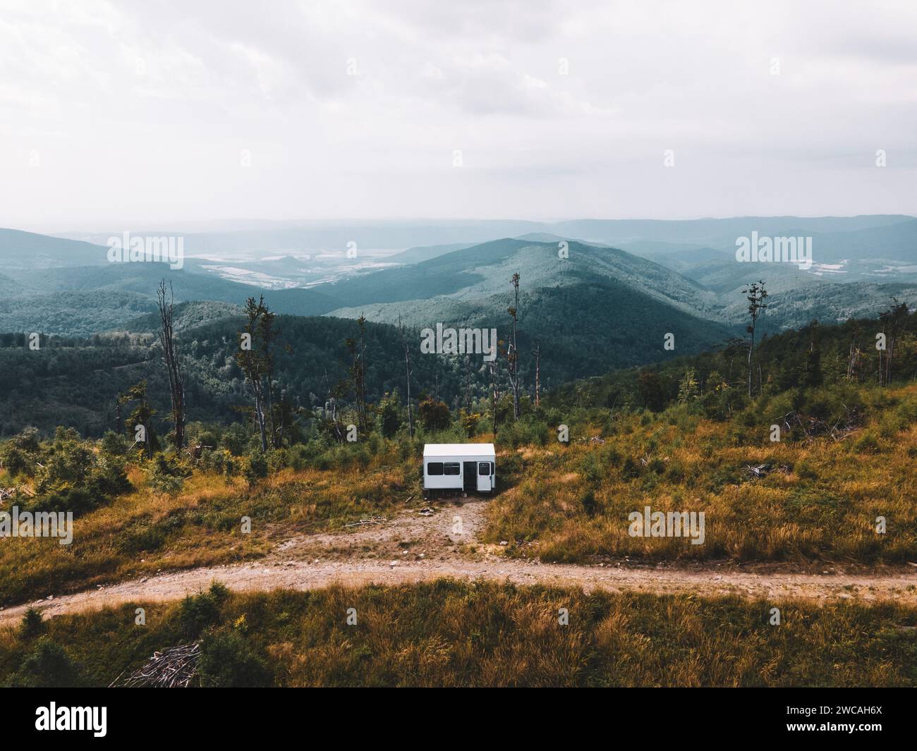 Aerial view of small camper trailer in the middle of summer forest ...