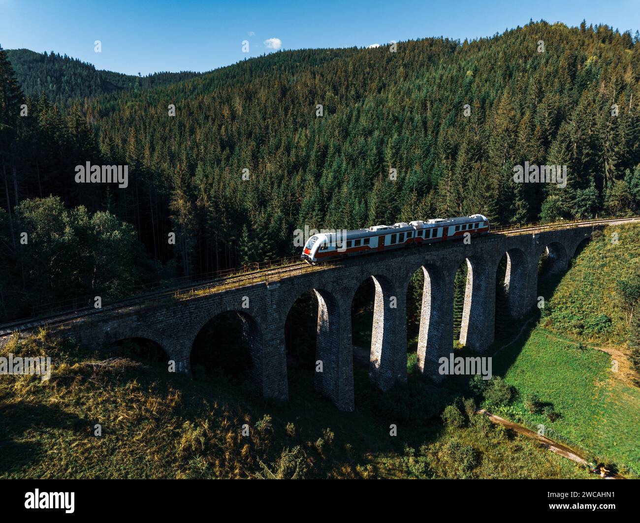 Aerial view of train on historical stone railway bridge in Slovakia ...