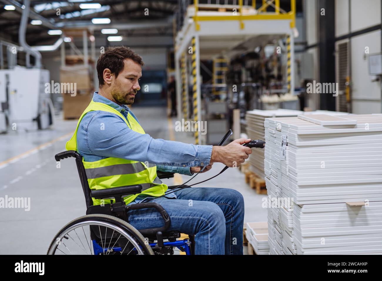Portrait of man in wheelchair working in modern industrial factory ...