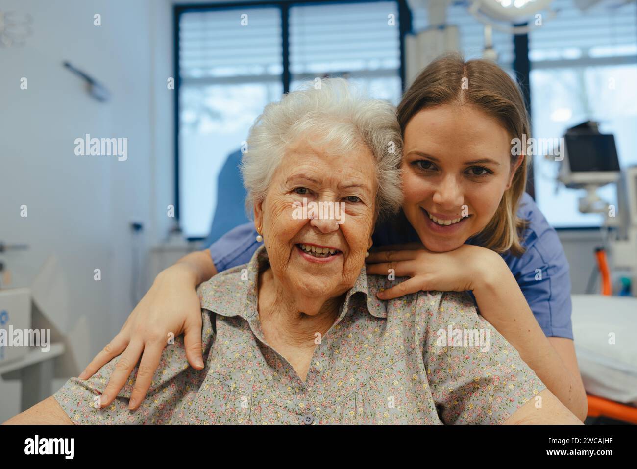 Portrait of nurse and senior patient talking in hospital corridor ...
