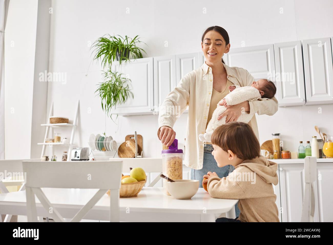jolly beautiful woman pouring corn flakes to her adorable toddler son ...