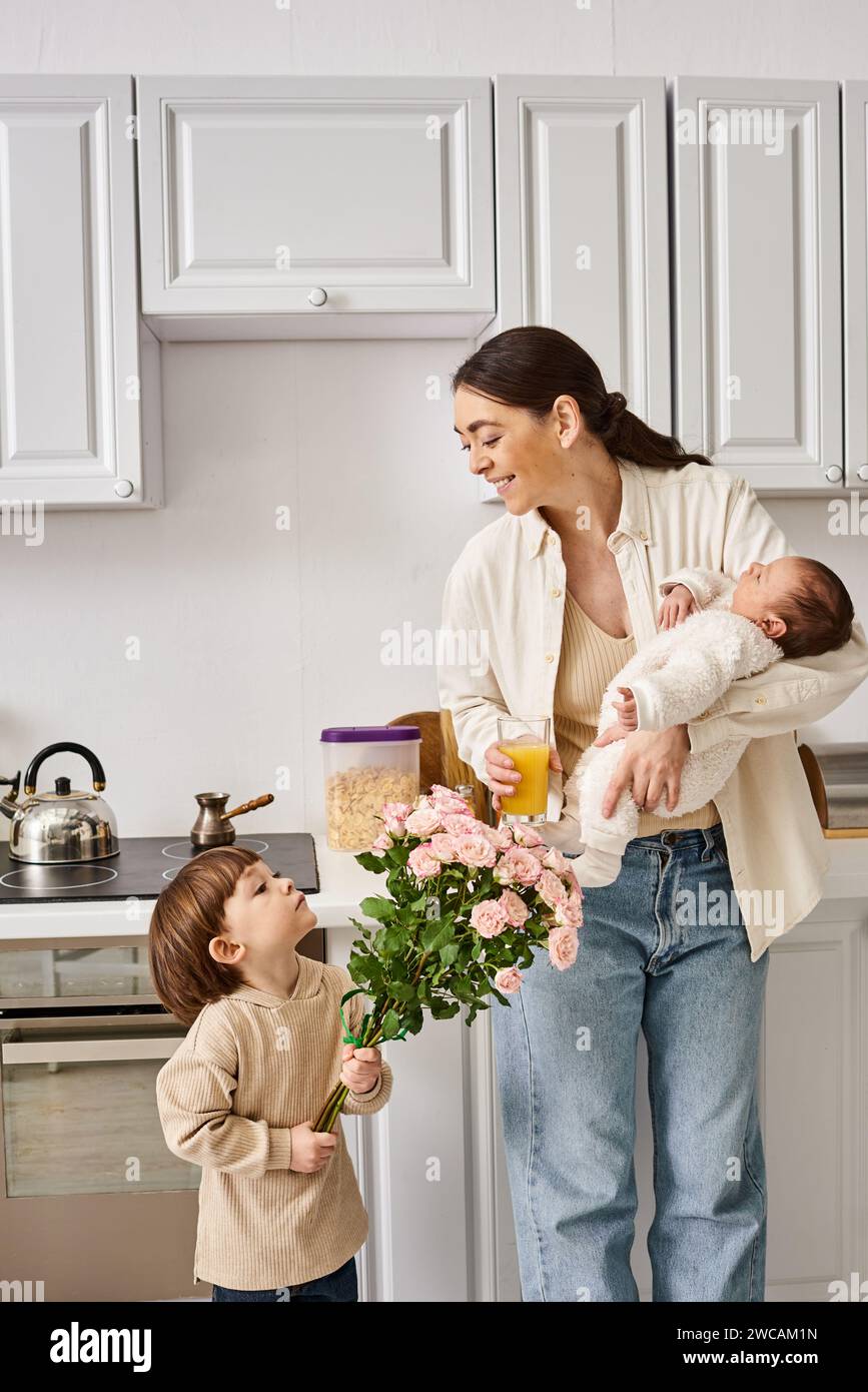 adorable toddler boy giving flowers to his beautiful jolly mother with ...