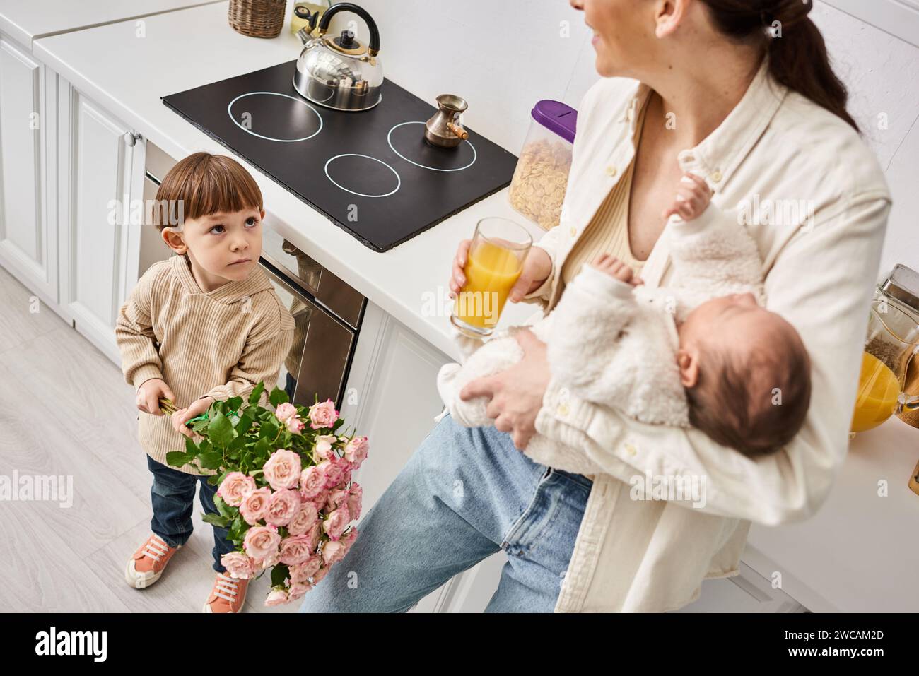 adorable toddler boy giving flowers to his beautiful happy mother with ...