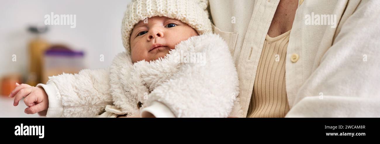 cute newborn baby in warm cozy attire in hands of his loving mother ...