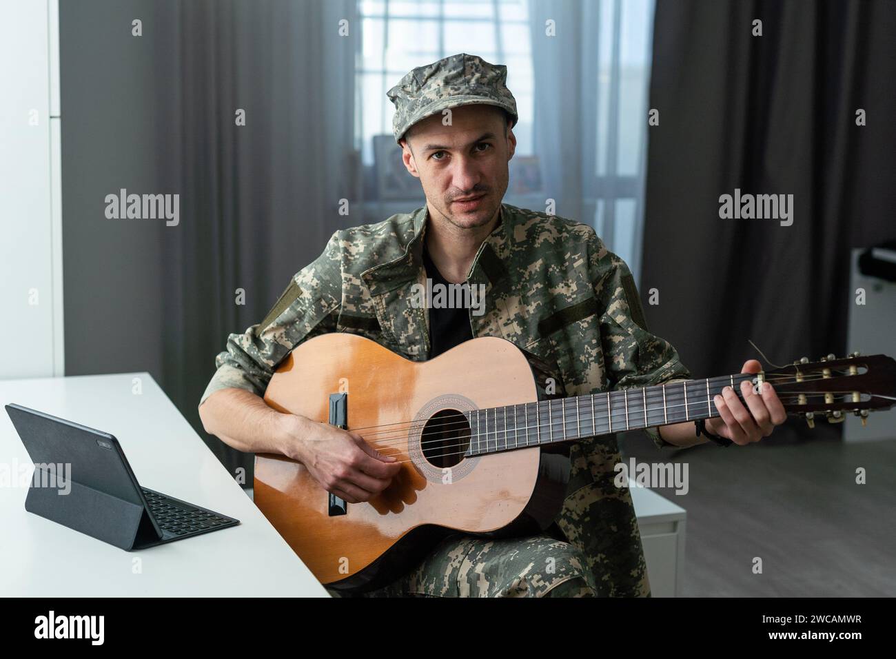 Cheerful smiling young military man wearing khaki uniform holding ...