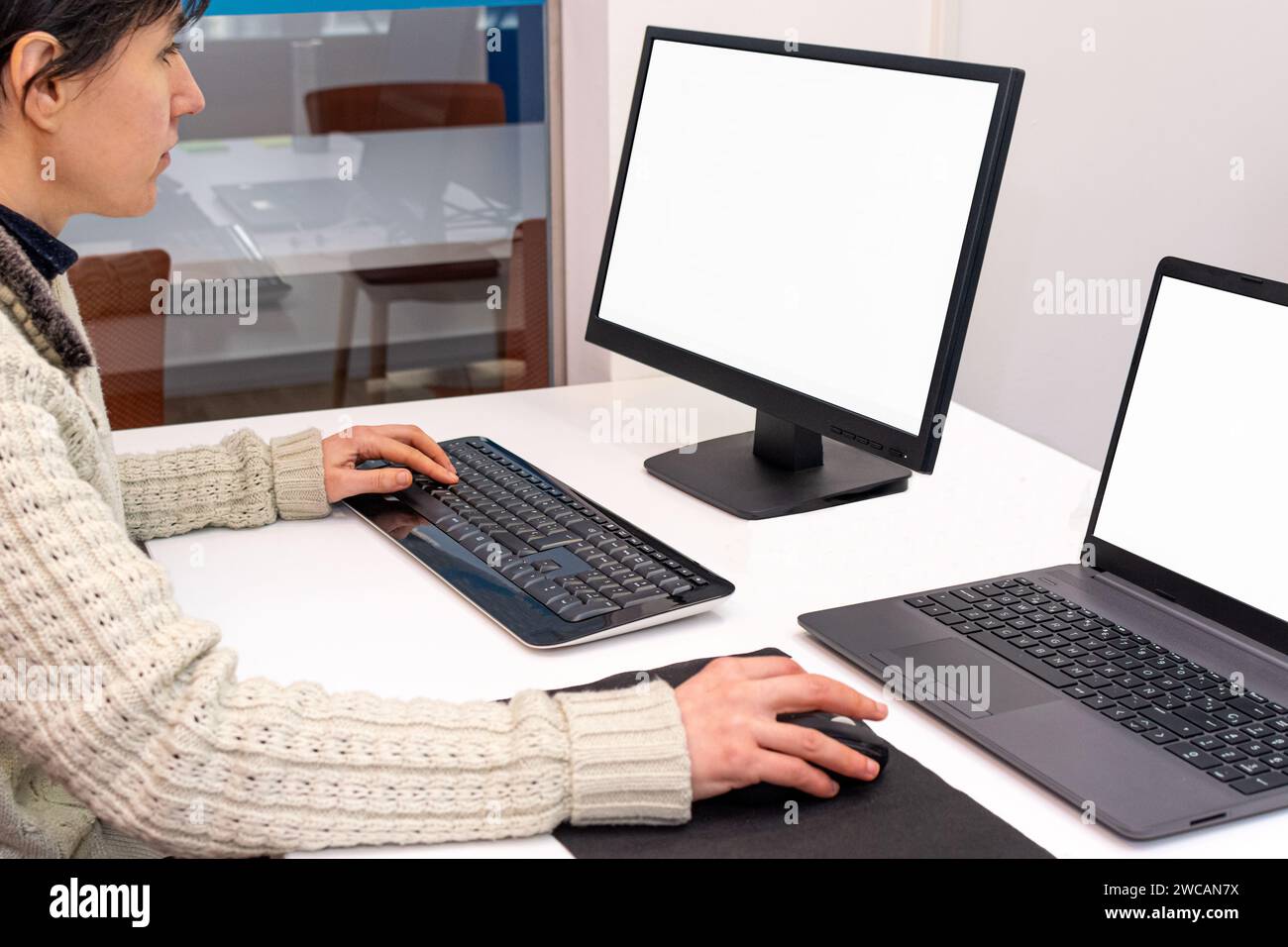 Caucasian woman working in the office driving a desktop computer and a ...