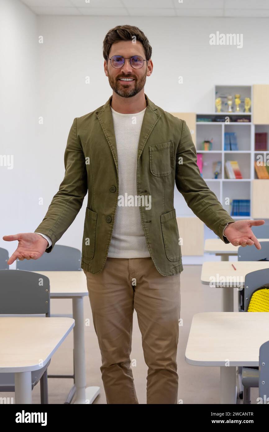 Man teacher standing alone in school classroom Stock Photo - Alamy
