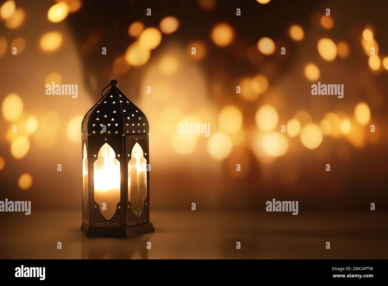 Dark silhouette of Moroccan lantern glowing at night. Glittering golden ...