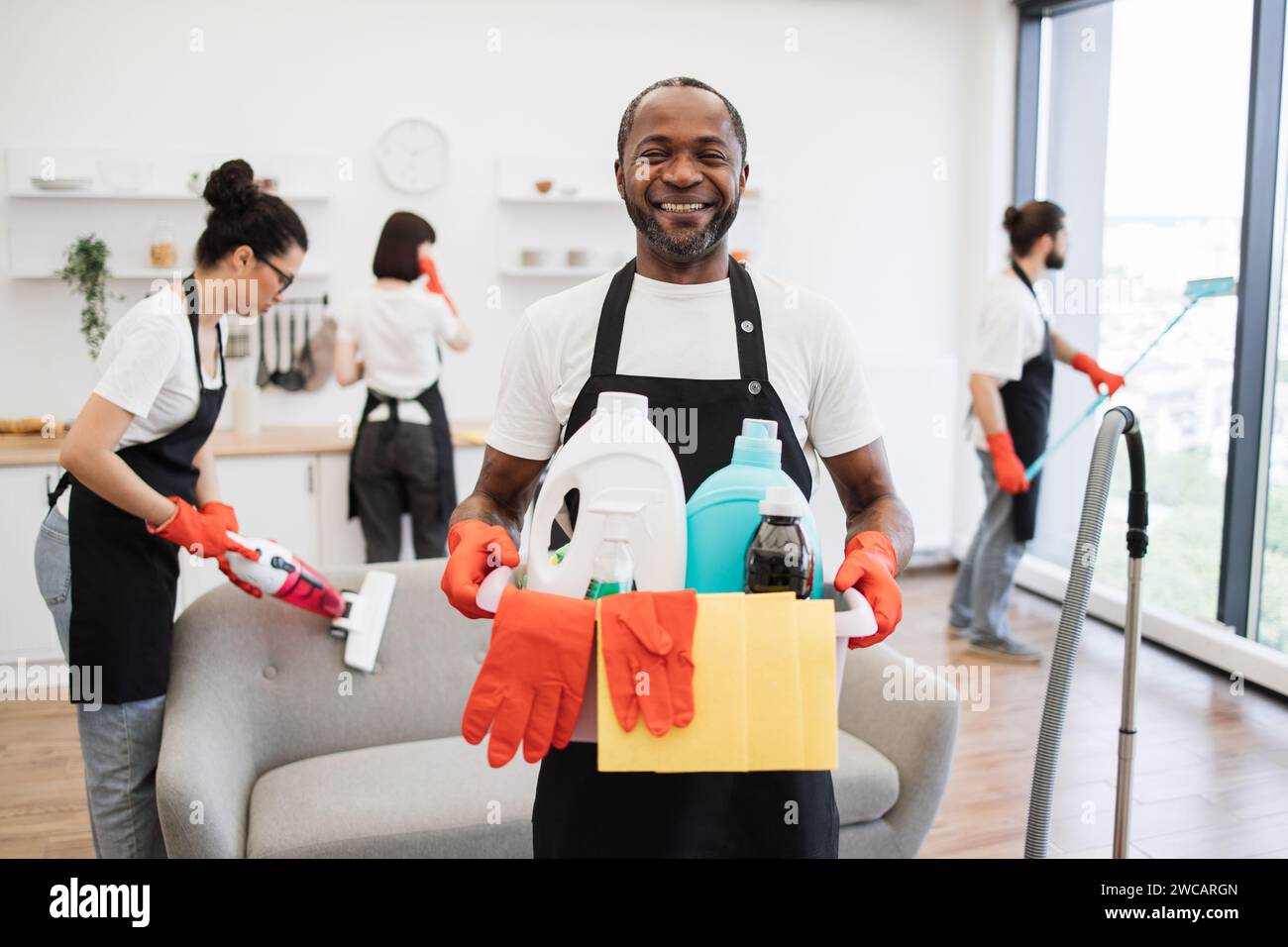 African man professional cleaning worker holding a bucket with ...