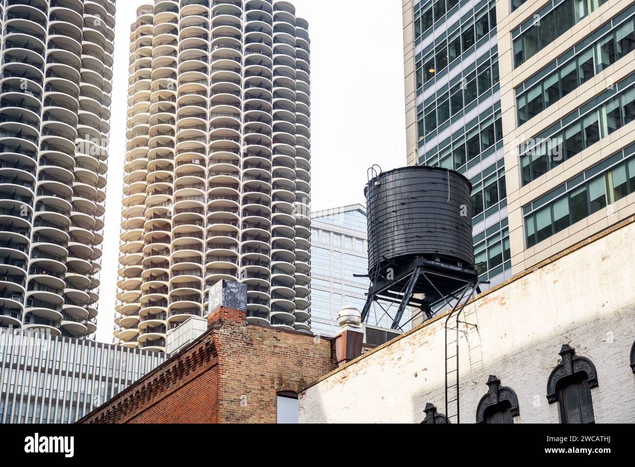 Water tank on the roof of an old brick building surrounded by modern ...