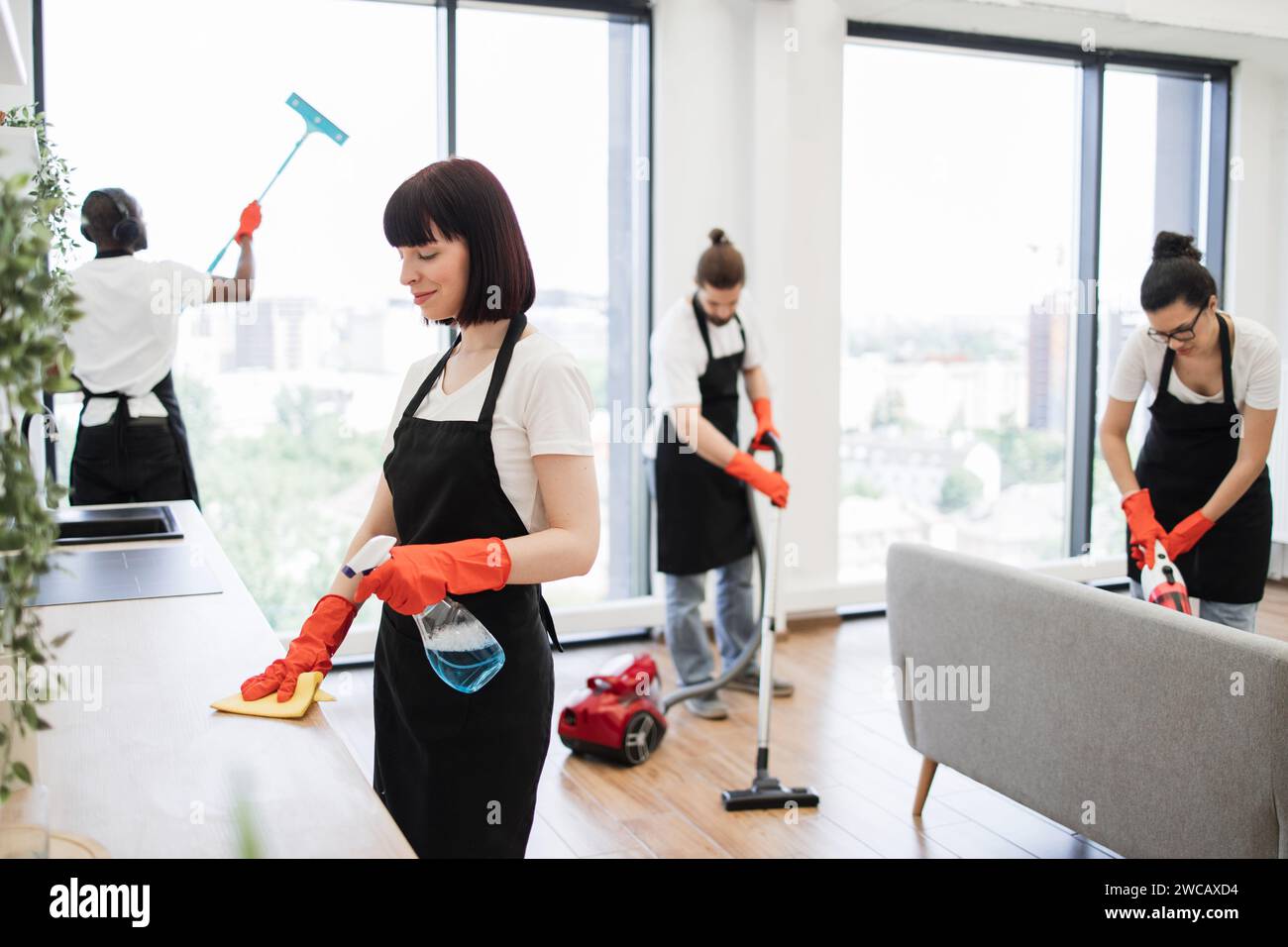 Caucasian janitor in apron cleaning table Stock Photo - Alamy