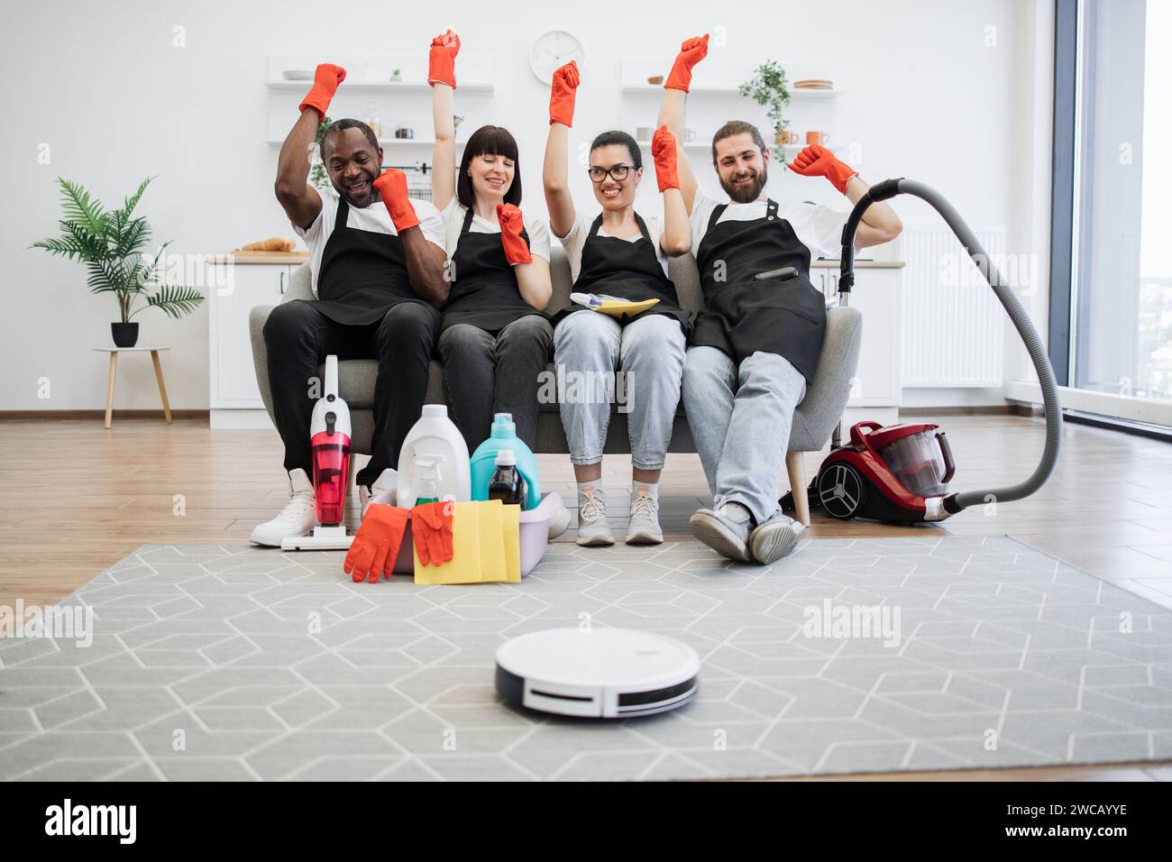 Robot vacuum cleaner cleans floor while team of housekeepers raising ...